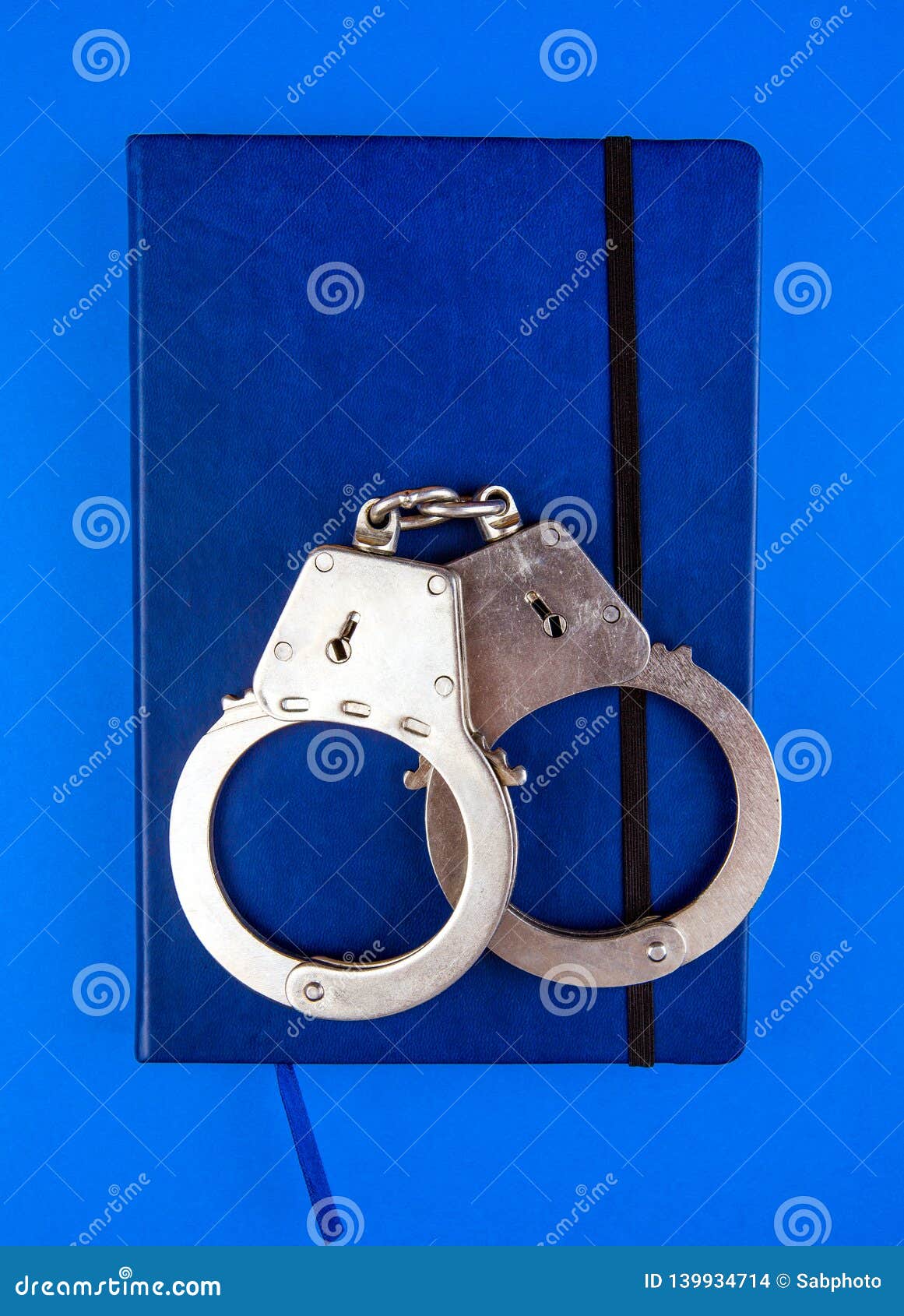 Blue Book and Handcuffs stock photo. Image of cuffs - 139934714