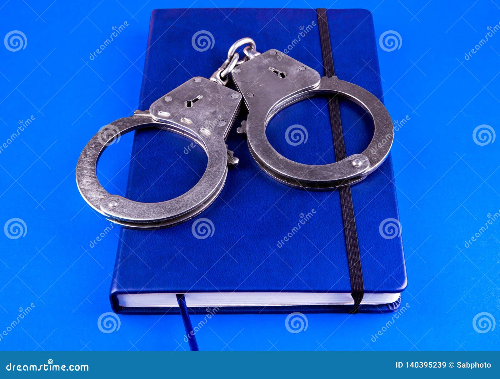 Blue Book and Handcuffs stock image. Image of criminalist - 140395239