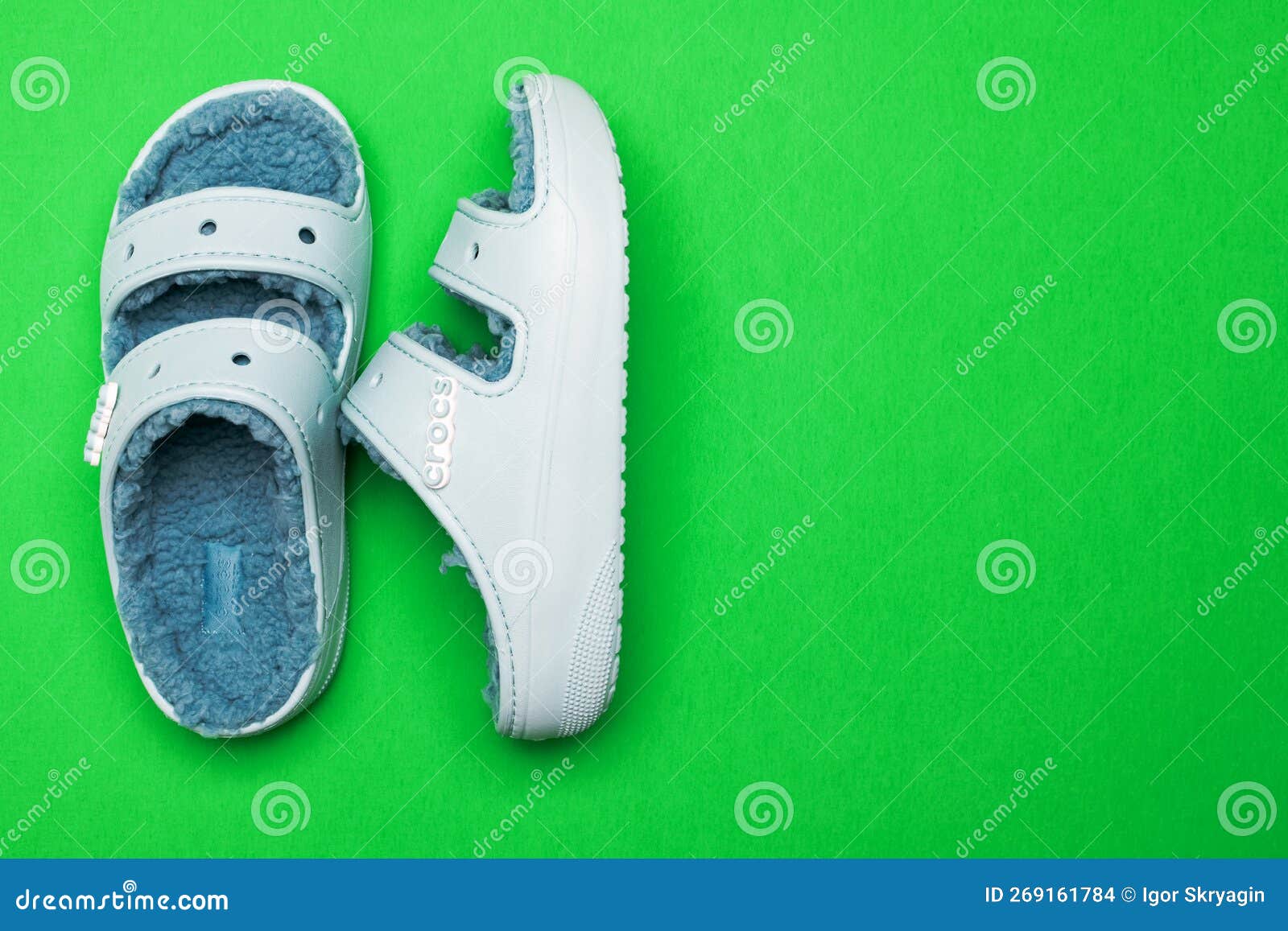 Blue Branded Crocs Sandals on Green Background. Top View, Space for ...