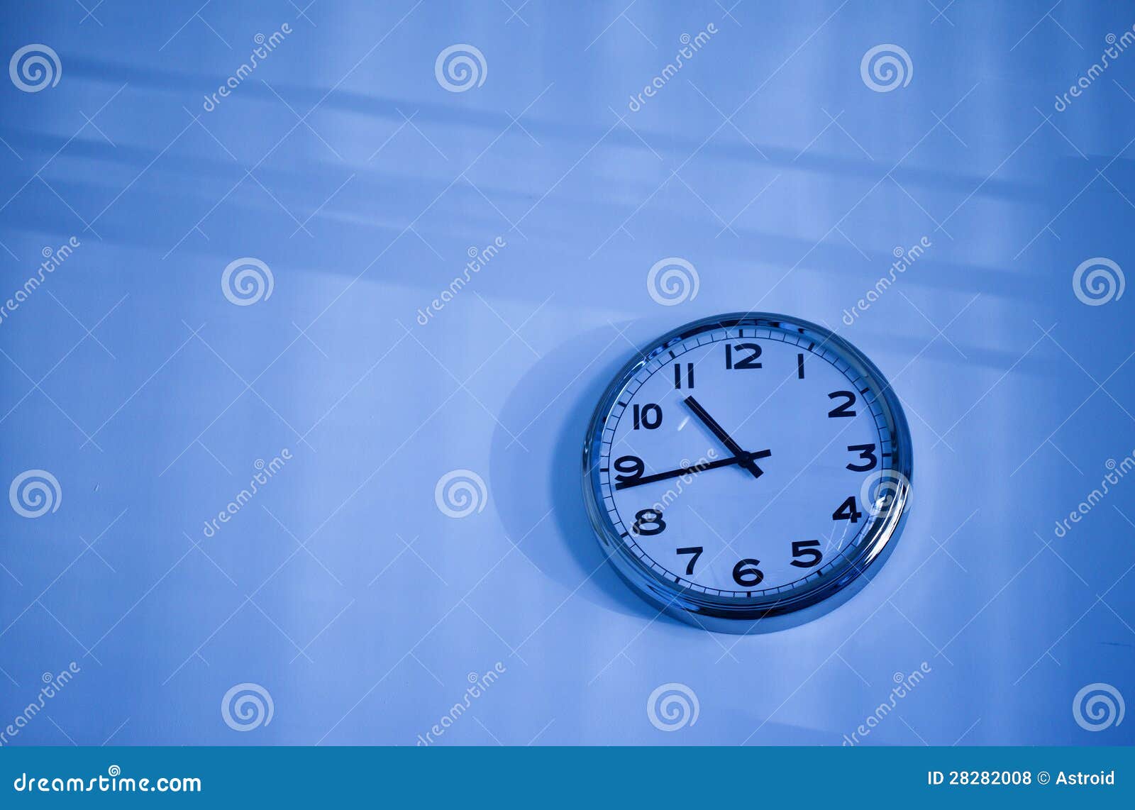 Blue clock on a blue wall stock photo. Image of focus - 28282008