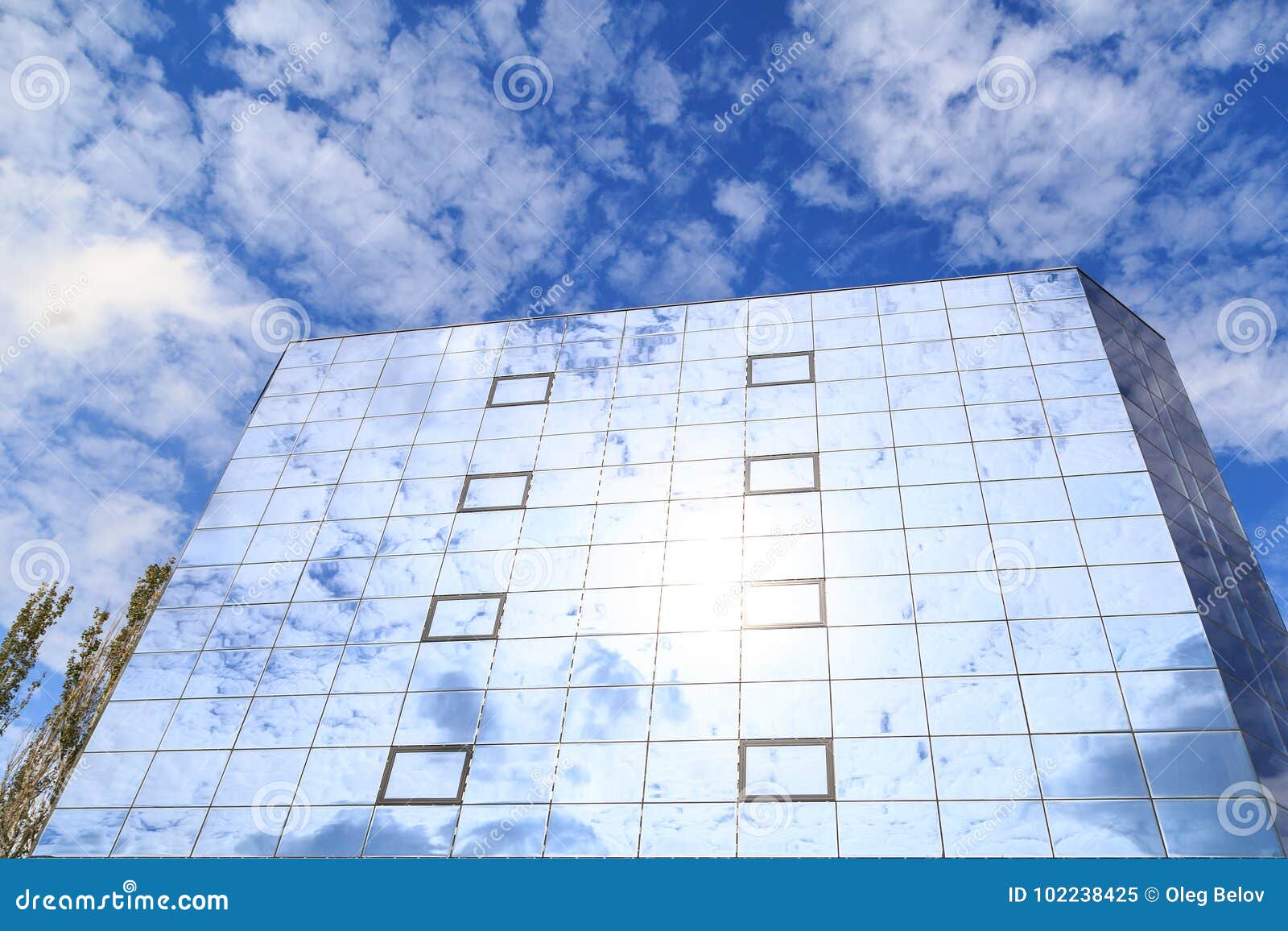 Blue Clouds and Trees are Reflected in the Glasses of Windows of a ...