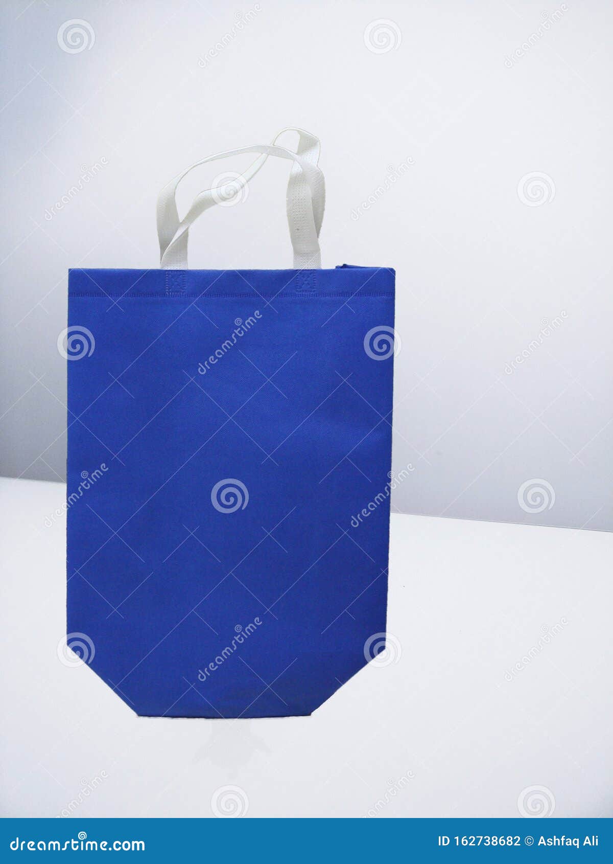 Blue Color Bag with White Handle, Eco Friendly Bag on White Table Stock ...