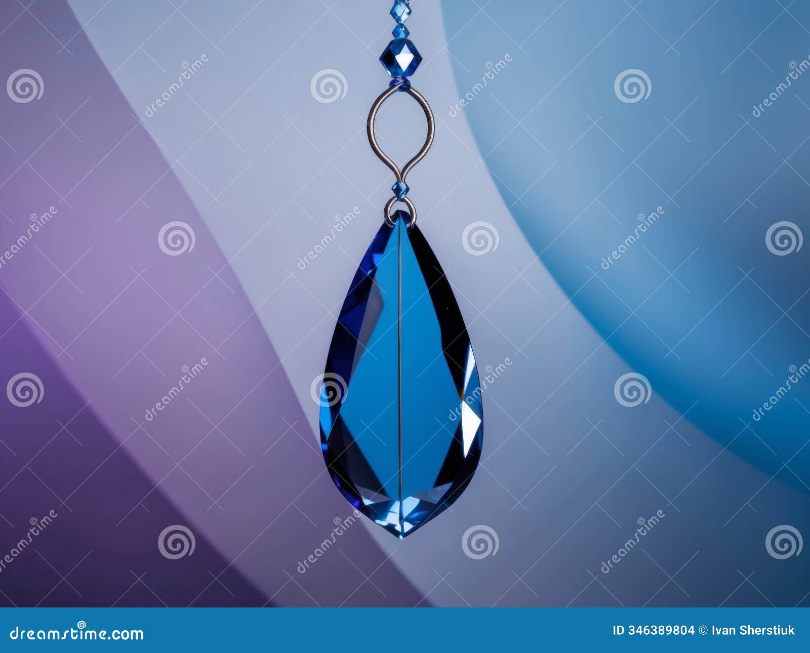 Blue Crystal Pendulum is Swinging on an Abstract Blue and Purple ...