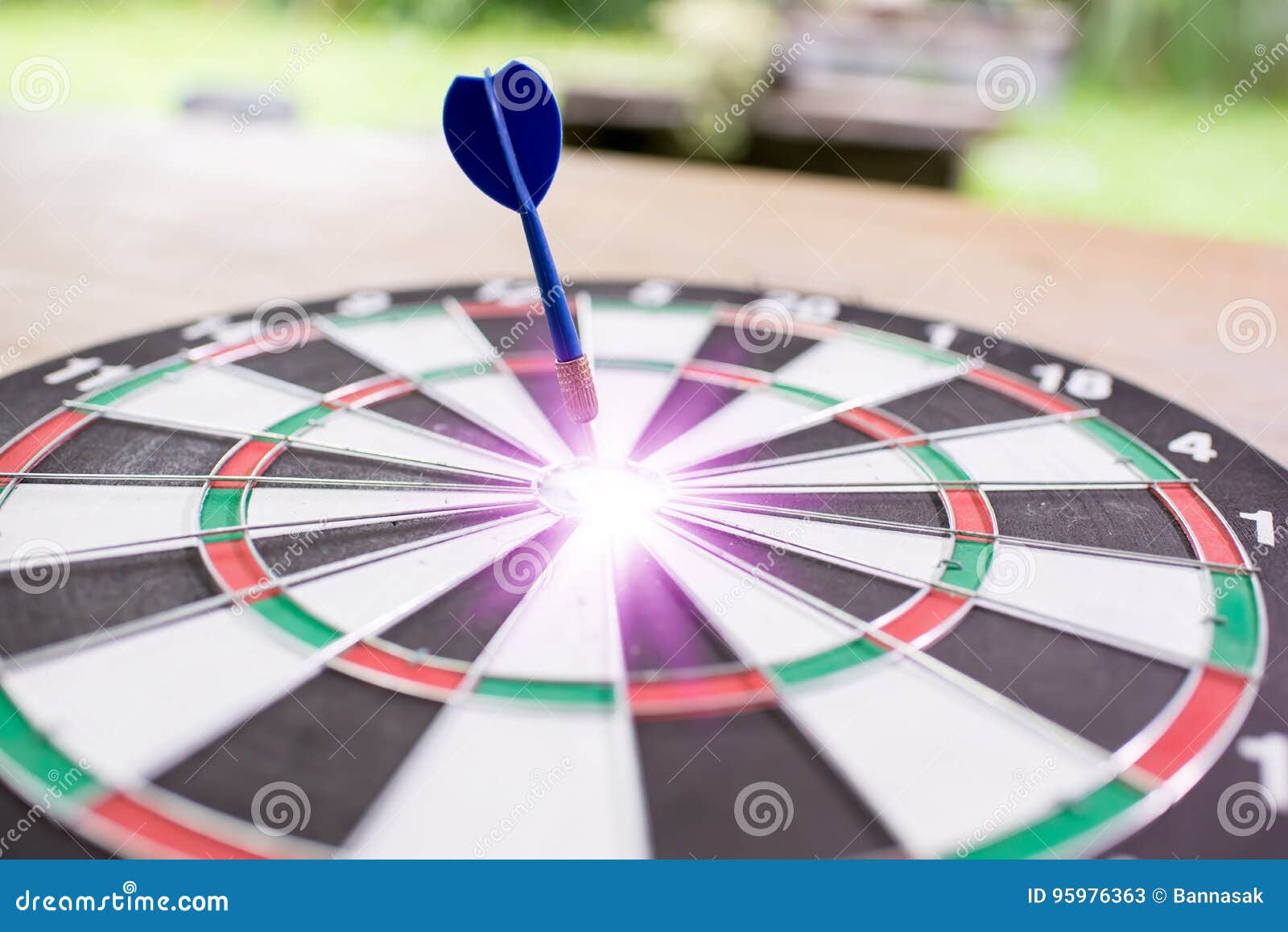 Blue Dart Arrow Hitting In The Target Center Of Dartboard With G ... Blue Dart Arrow Hitting In The Target Center Of Dartboard With G ...
