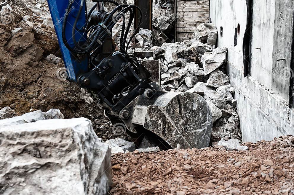 Blue Digger Digging a Construction Site with a Pile of Dirt and Rocks ...