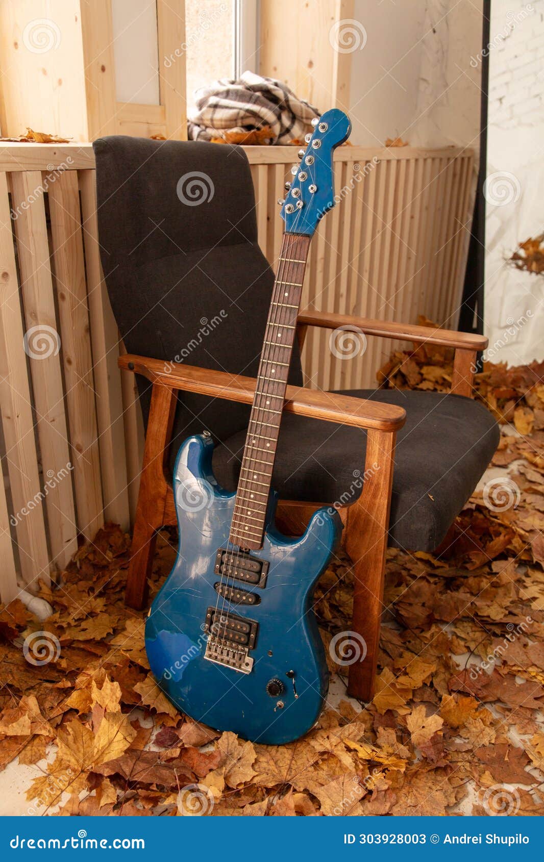 A Blue Electric Guitar Stands by a Chair Stock Image - Image of ...