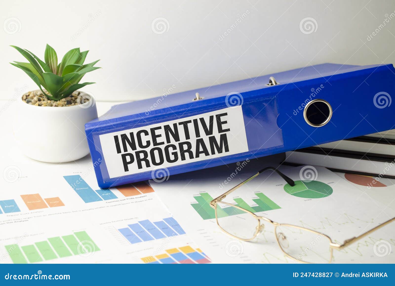 On a Blue Folder a Incentive Program Sign with Charts and Glasses Stock ...
