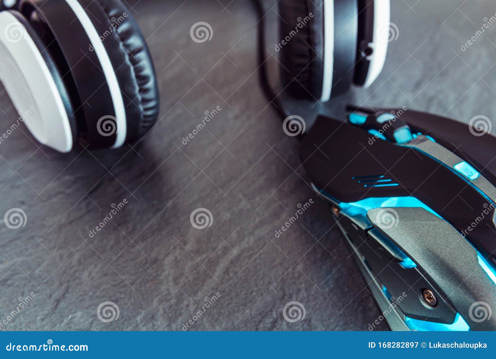 Blue Gaming Mouse with White Headphones on Stone Texture Table Stock ...