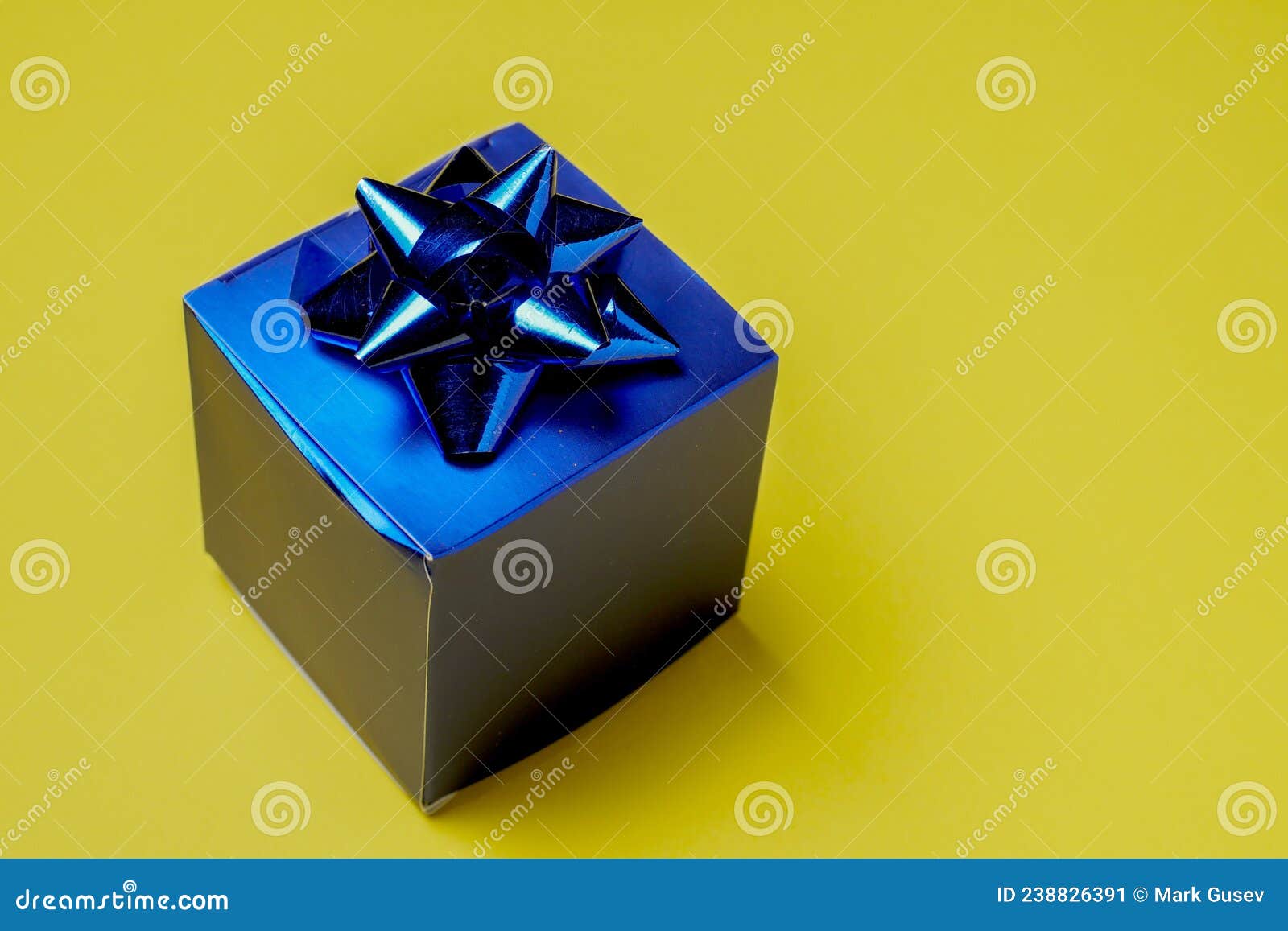 Blue Gift Box with Bow on a Yellow Background. Special Present Wrapped ...