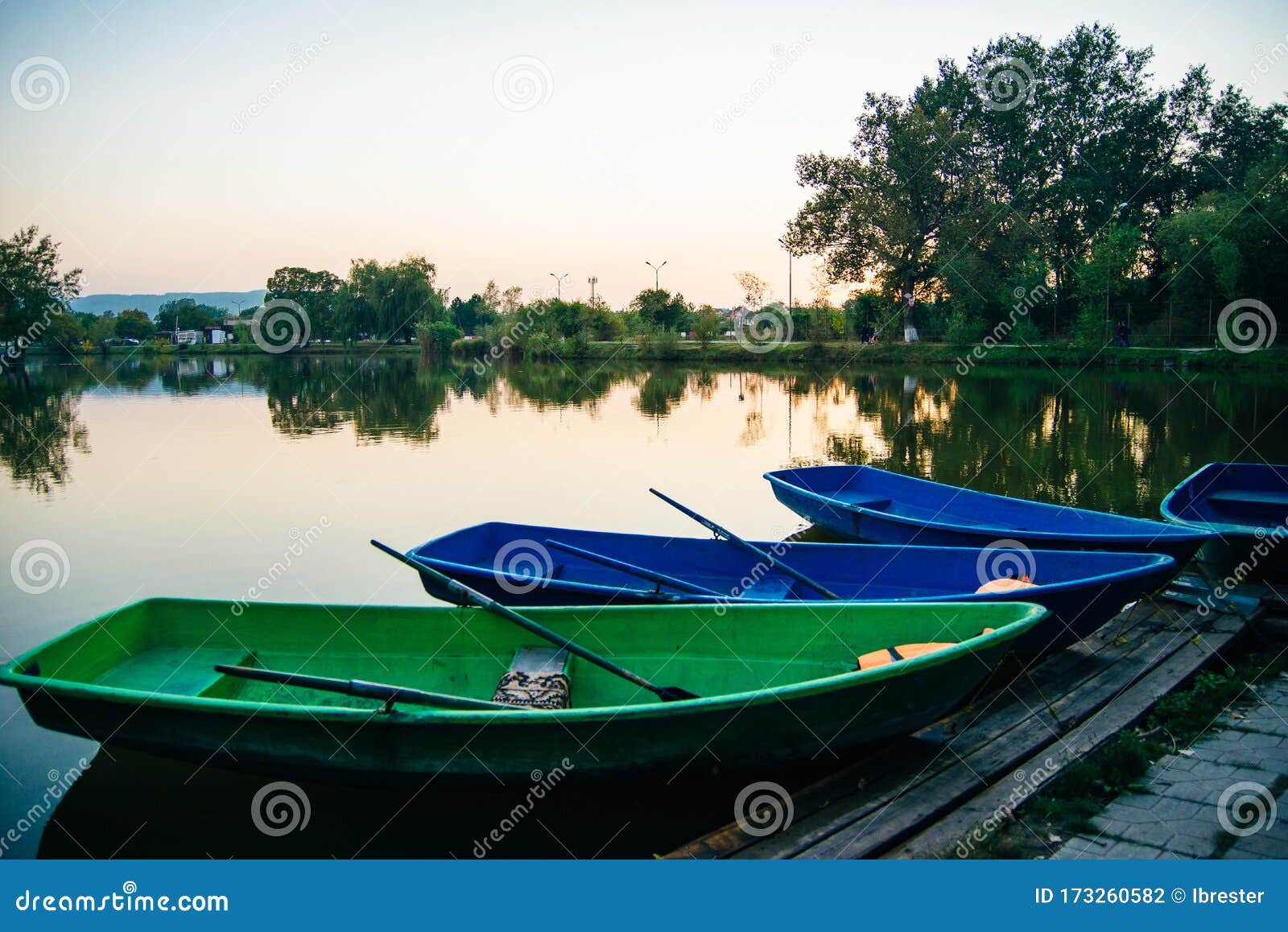 Blue and Green Boats on the Lake at Sunset Stock Photo - Image of ...