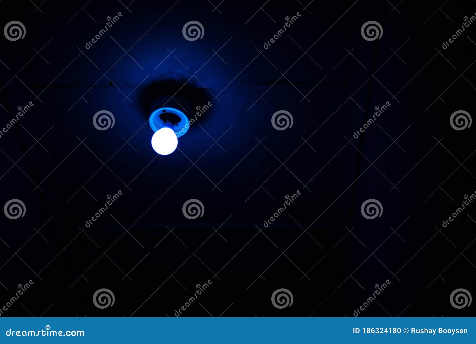 Blue Light Shining in Dark Room Against Ceiling Stock Photo - Image of ...