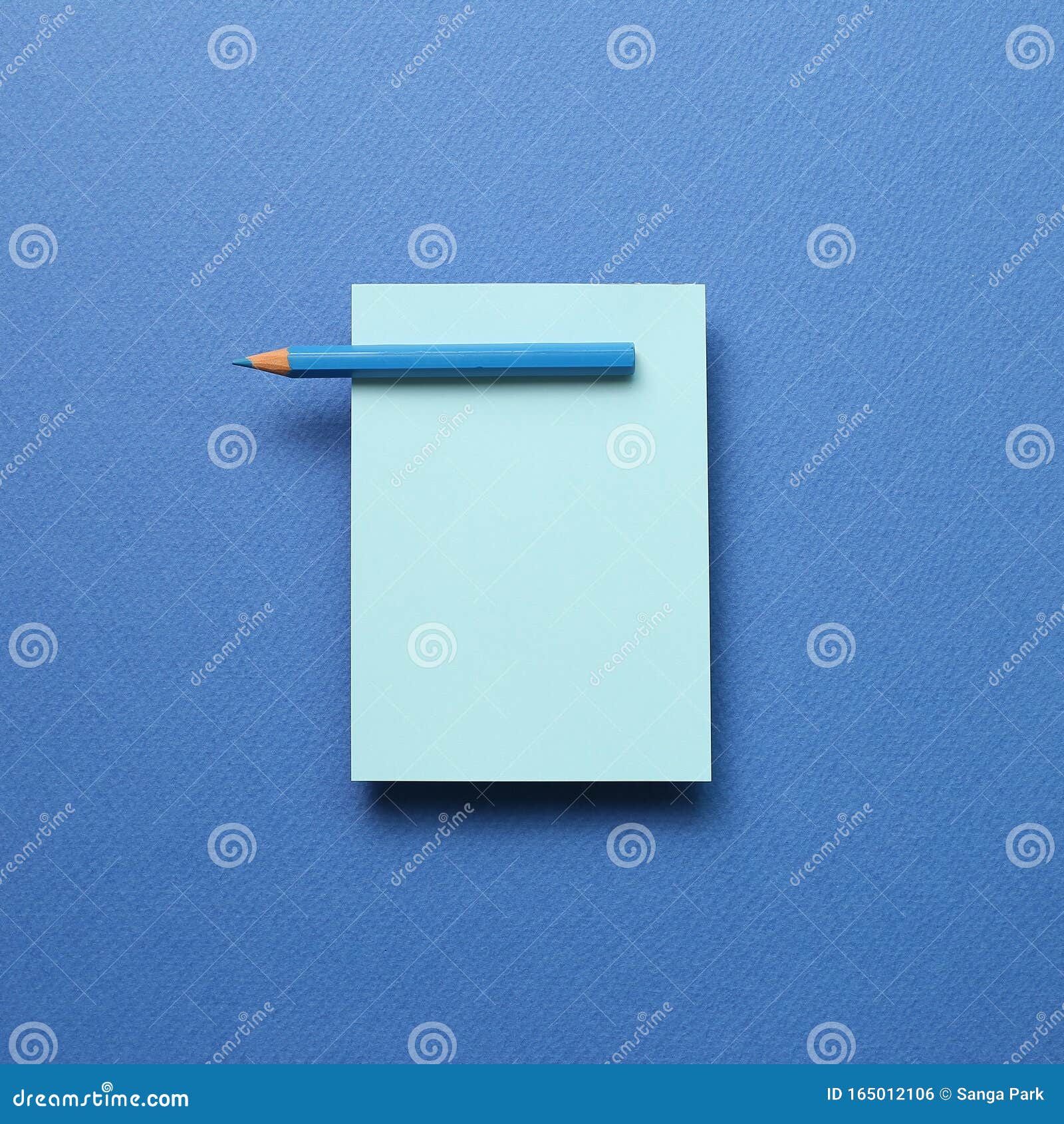 Blue Memo Note Pad and Blue Colored Pencil on Blue Background Stock ...