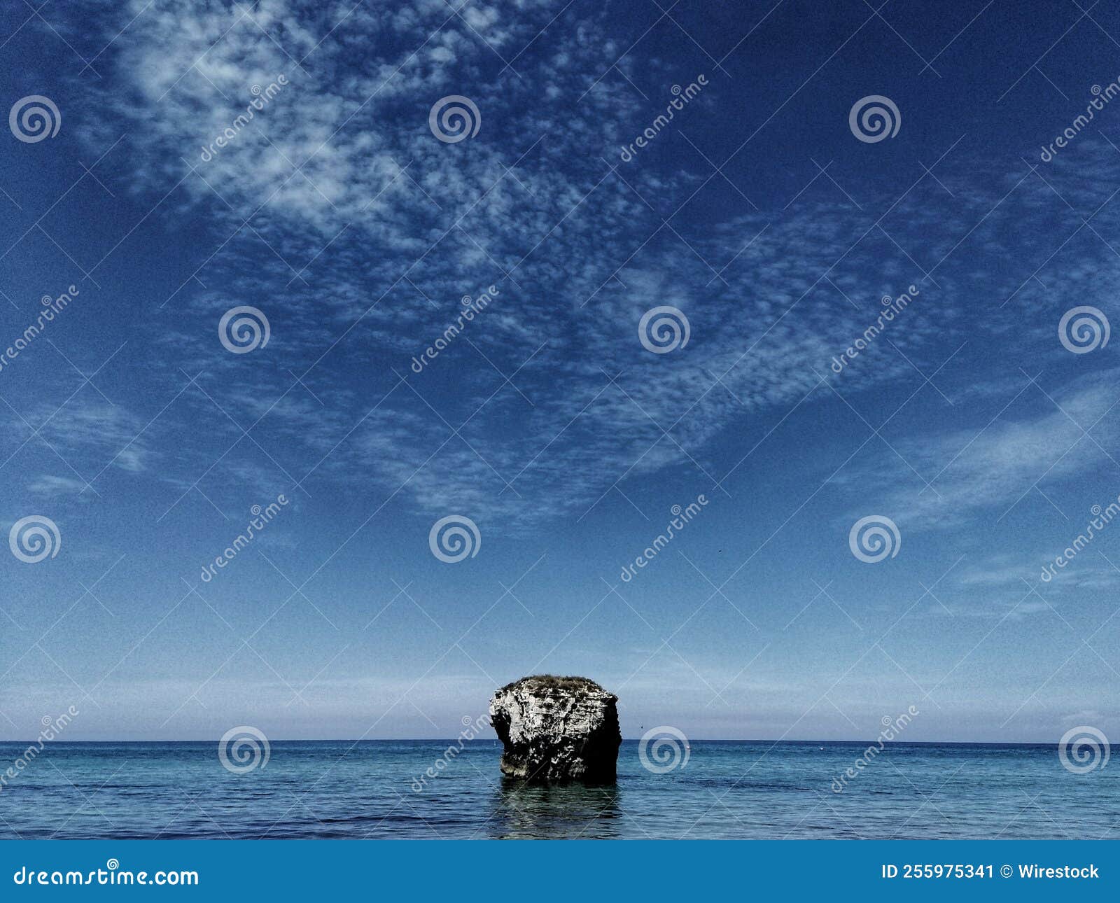 Blue Ocean with the Reflection of Blue Sky and a Stone in Stock Image ...