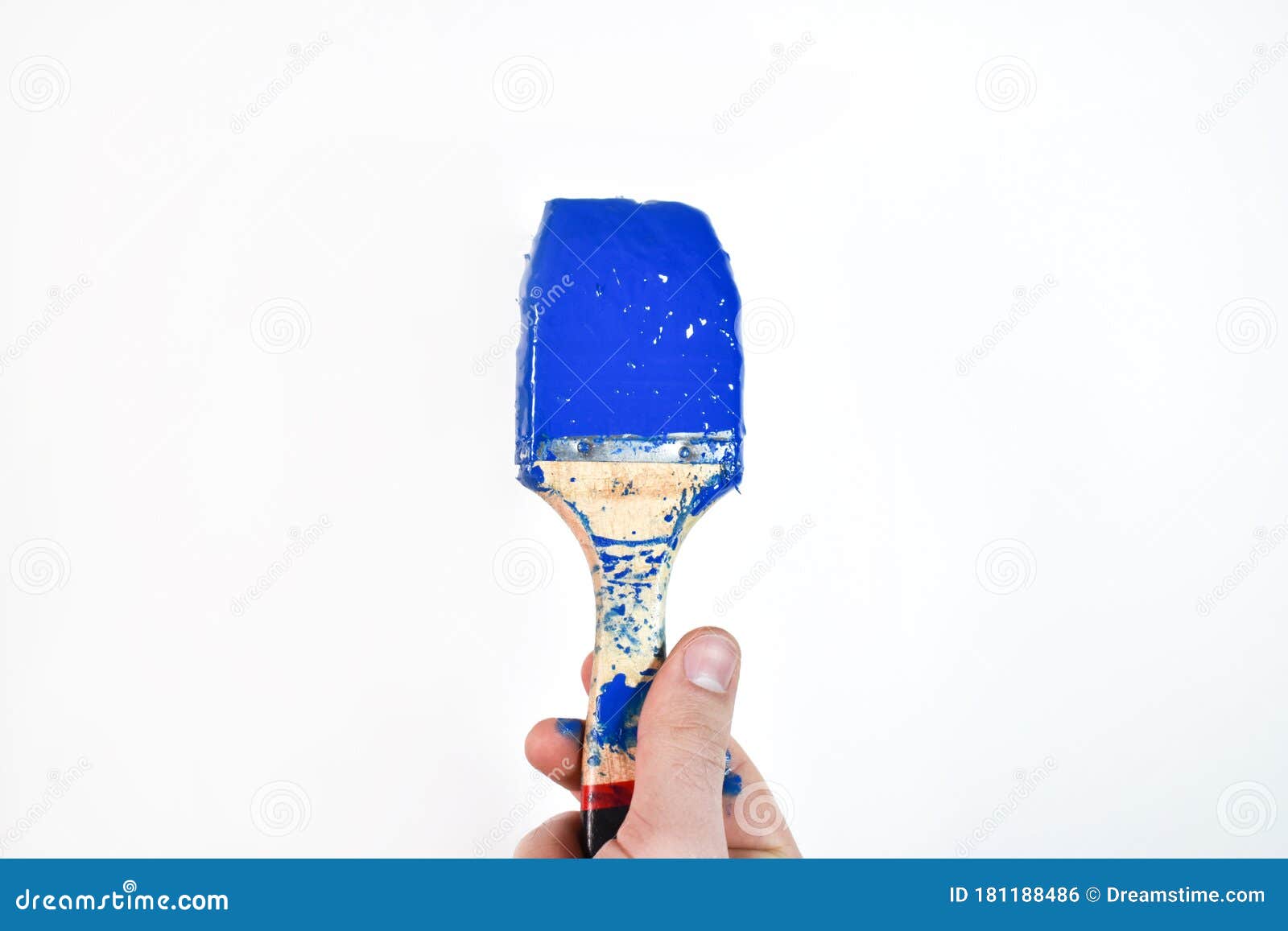 Blue paintbrush in a hand stock photo. Image of design - 181188486