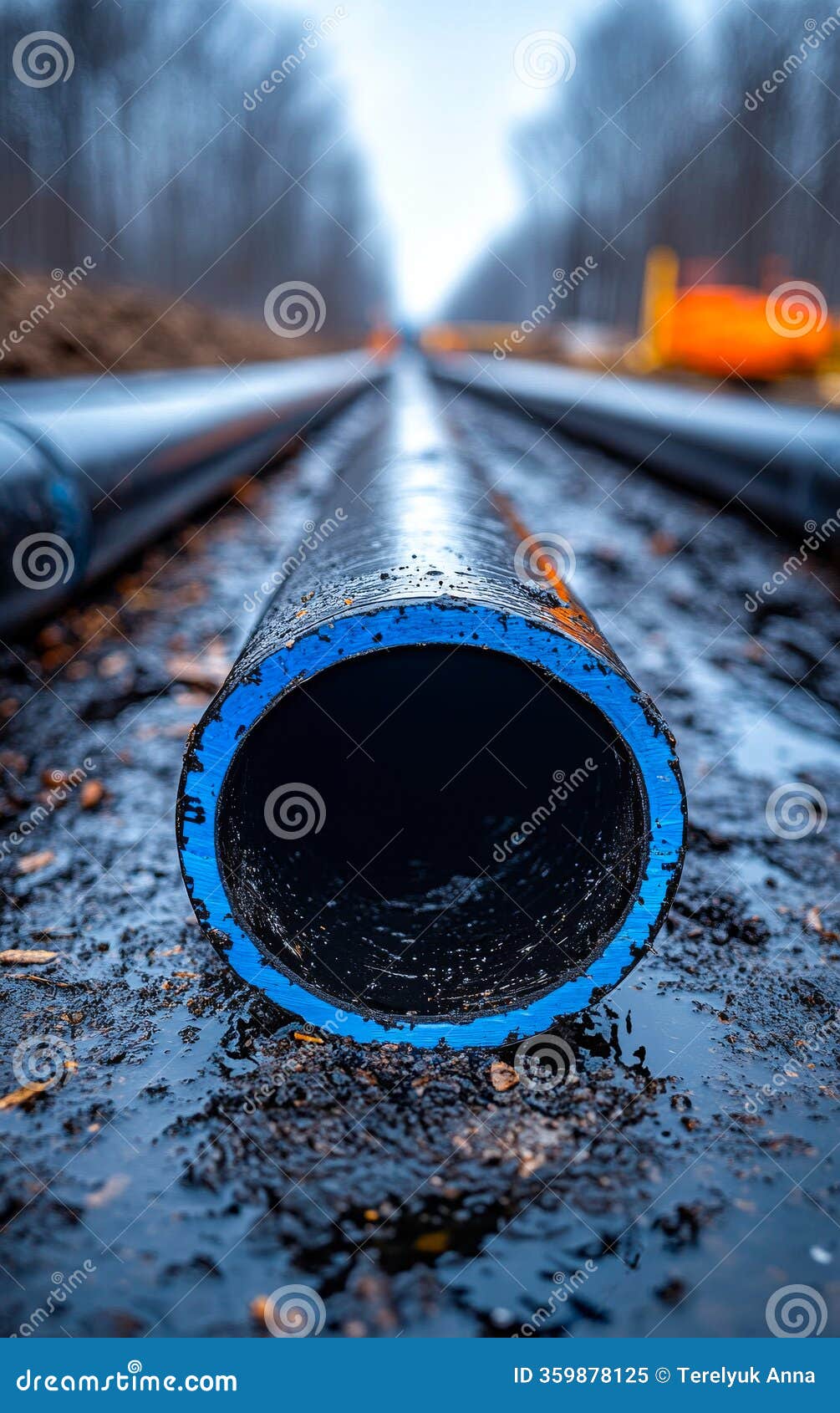 A Blue Pipe is Shown in the Foreground of a Muddy Field Stock Image ...