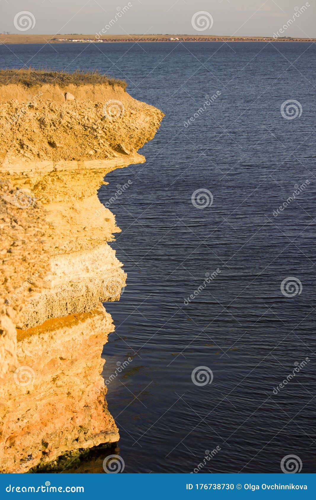Blue Sea and Rocky Cliff Backlit by the Setting Sun. Vertical Photo ...
