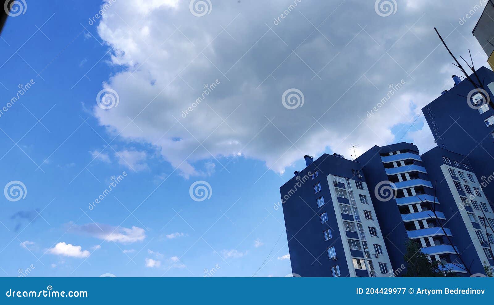 Blue Sky with Huge Cloud Against the Background of Dark Blue High-rise ...