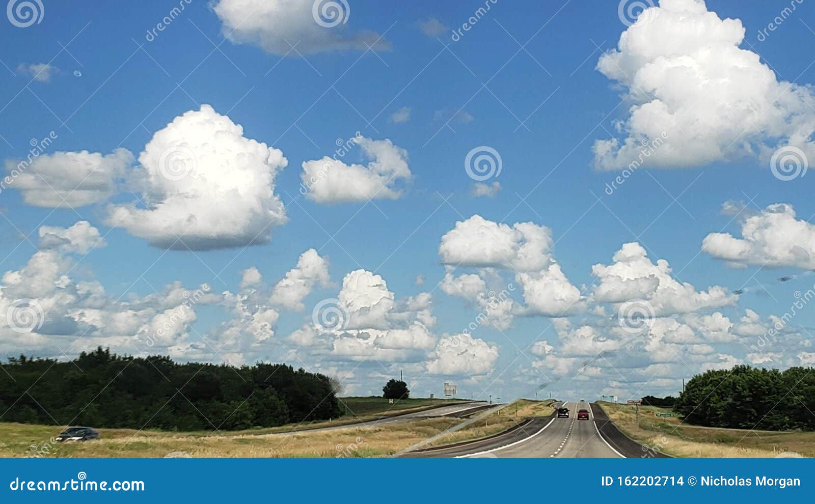 Blue Sky with Patchy Clouds and Long Country Road Stock Photo - Image ...