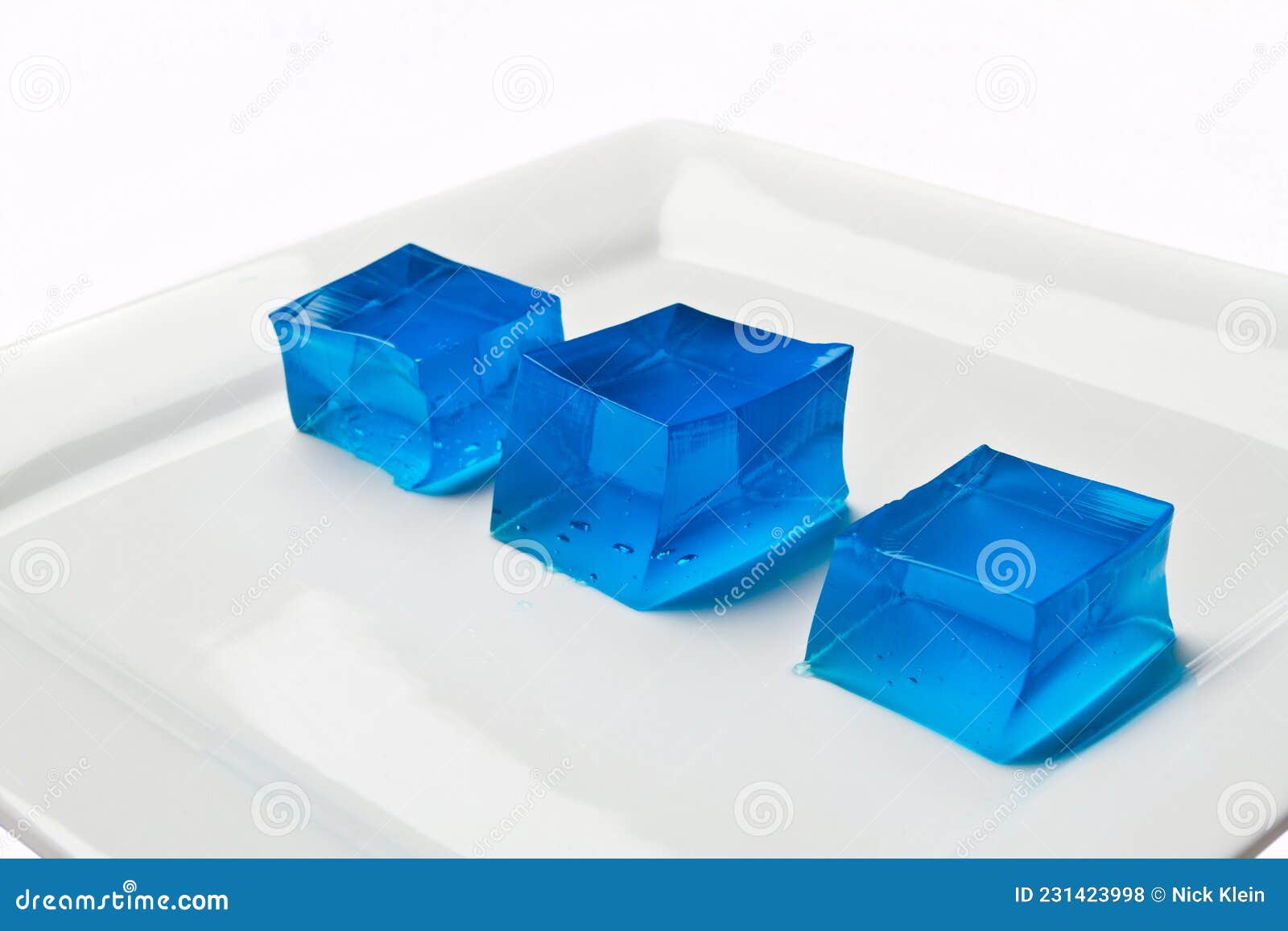 Blue Squares of Wiggly Jello on a White Plate Against a White ...