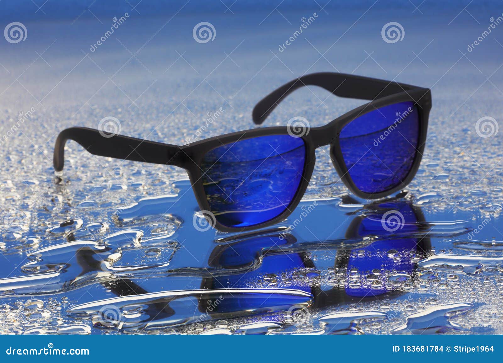 Blue Sunglasses With Black Frames On Water Reflection With Selective