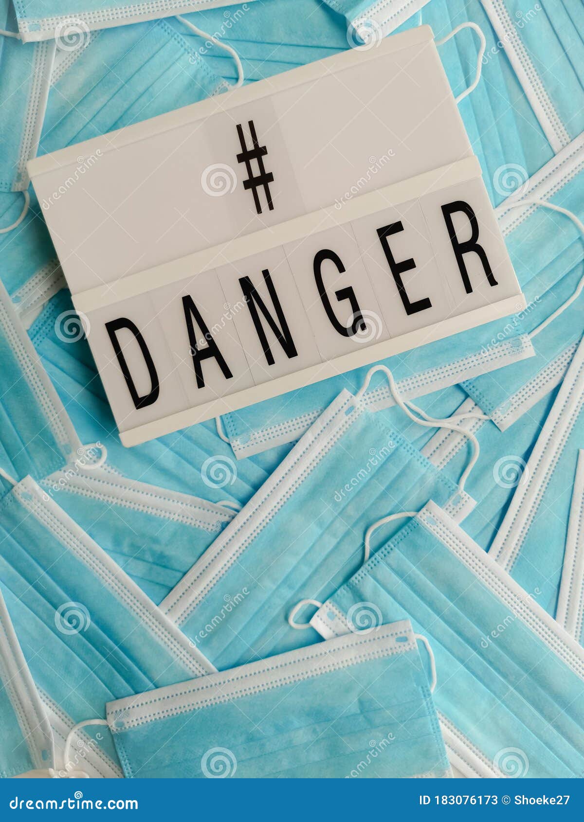 Blue Surgical Face Masks with a White Light Box Stating # Danger Stock ...