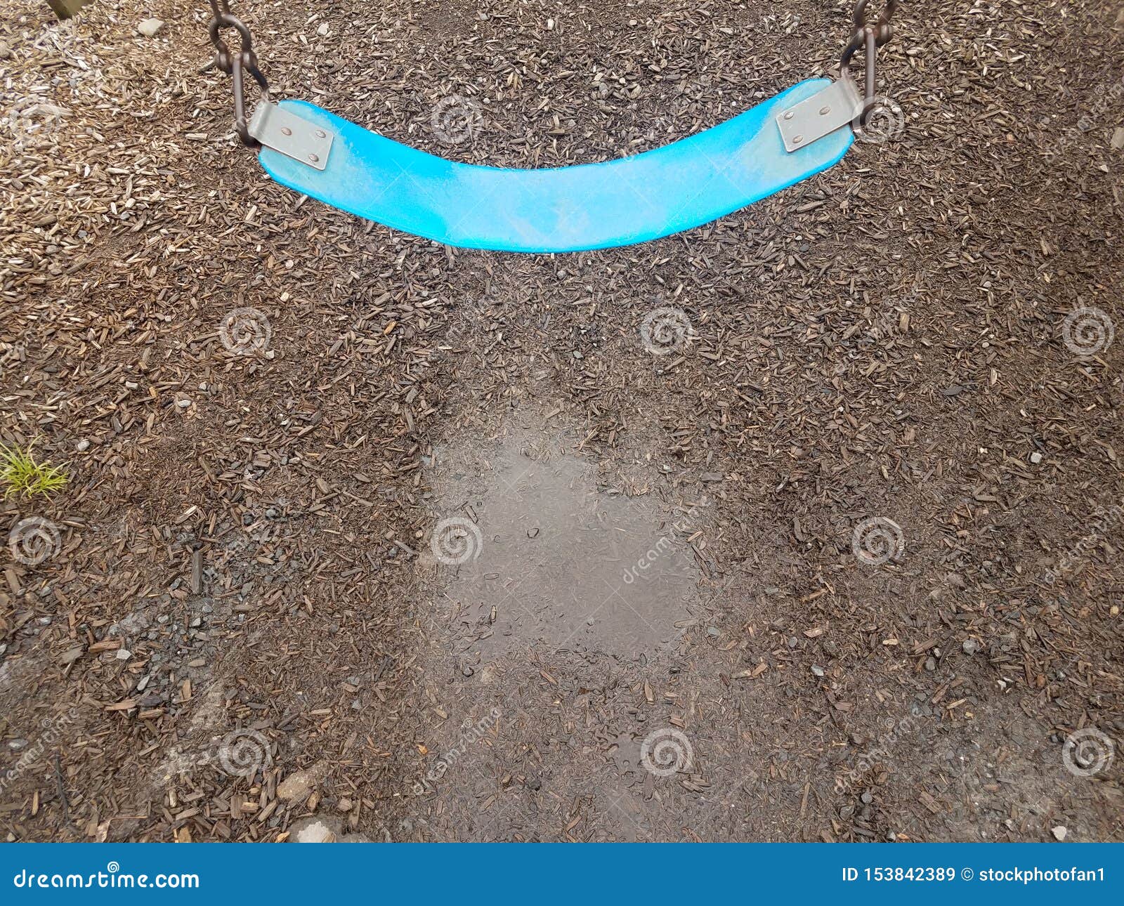 Blue Swing on Playground with Water Puddle and Wood Chips Stock Image ...