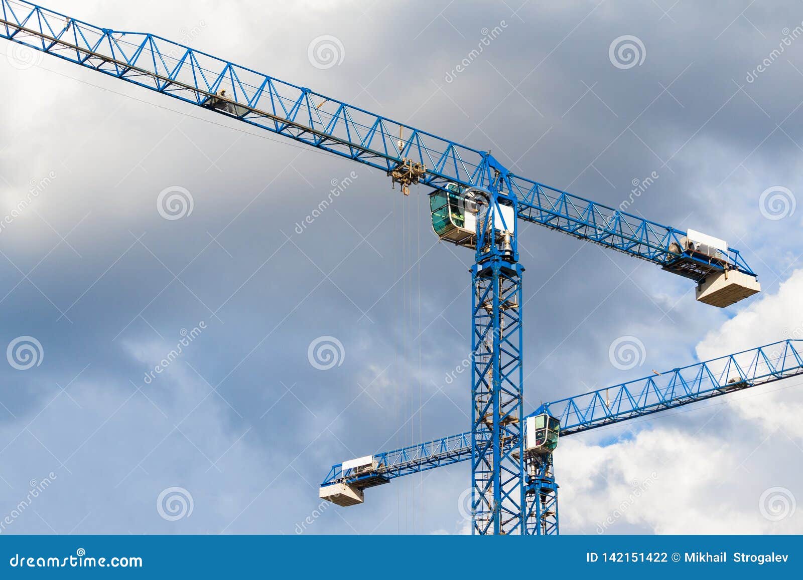 Blue tower cranes stock photo. Image of architecture - 142151422