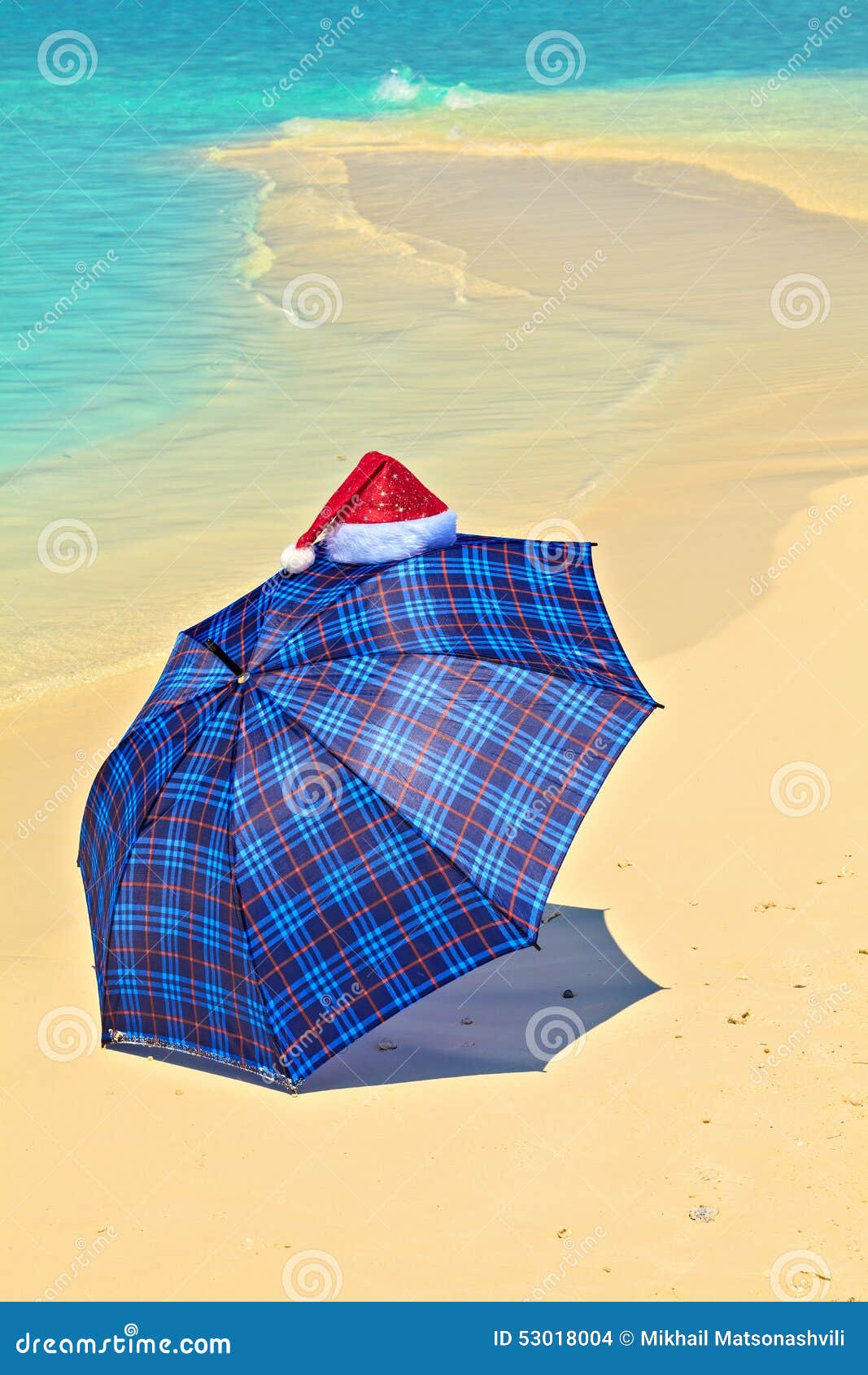 Blue Umbrella is on a Beach with Santa Hat Stock Photo - Image of ...