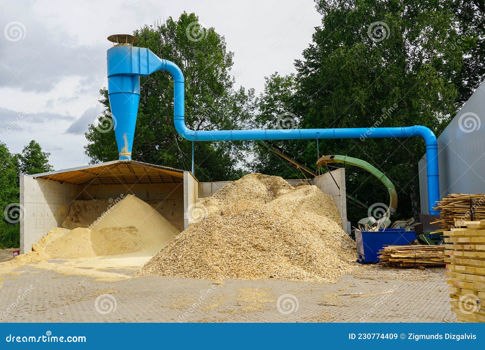 Blue Ventilation Pipe and a Stack of Sawdust Under it in the Sawmill ...