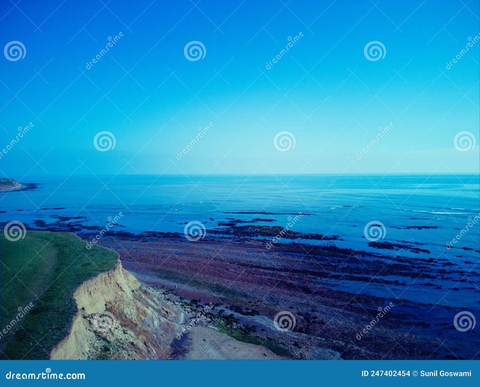 Blue Water Ocean Beach Muddy Cliffside Stock Photo - Image of clouds ...