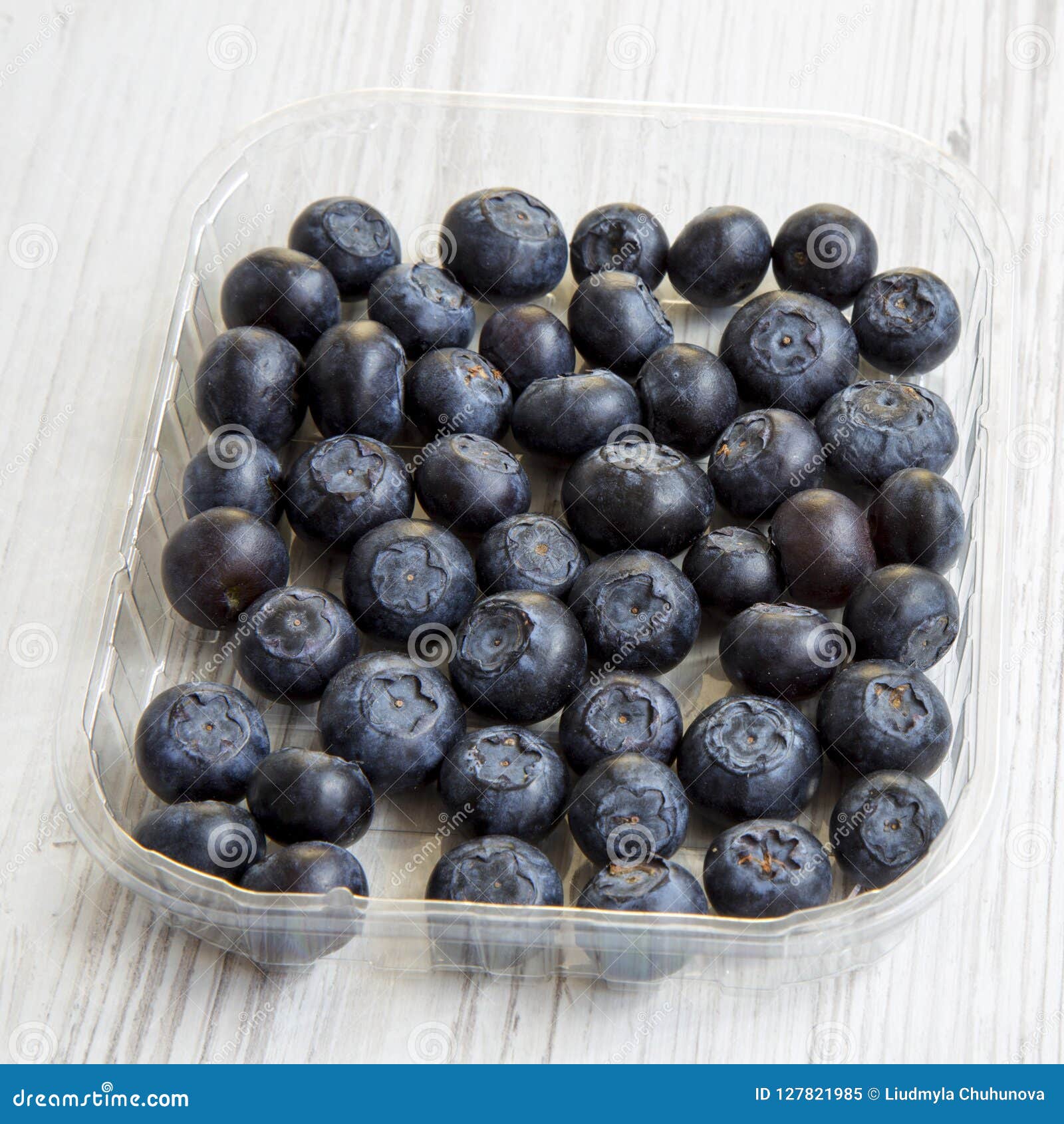 Blueberries in a Plastic Box Over White Wooden Background, Side View ...