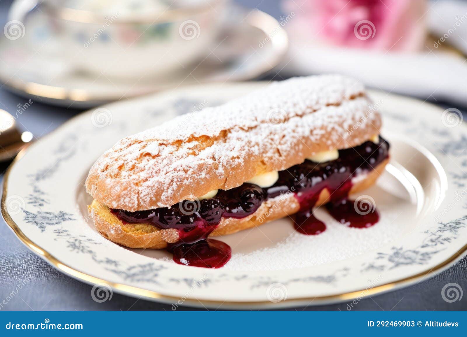 Blueberry Jam-filled Eclair Dusted with Icing Sugar on a Saucer Stock ...