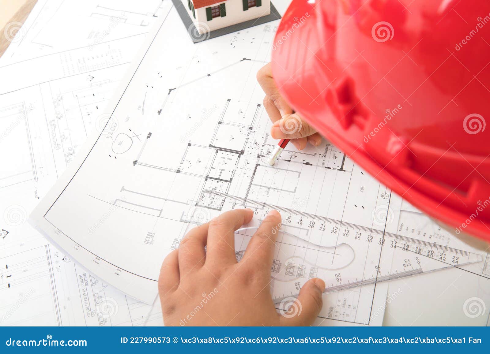 Blueprint Designer Wearing Red Hard Hat at Work Stock Image - Image of ...
