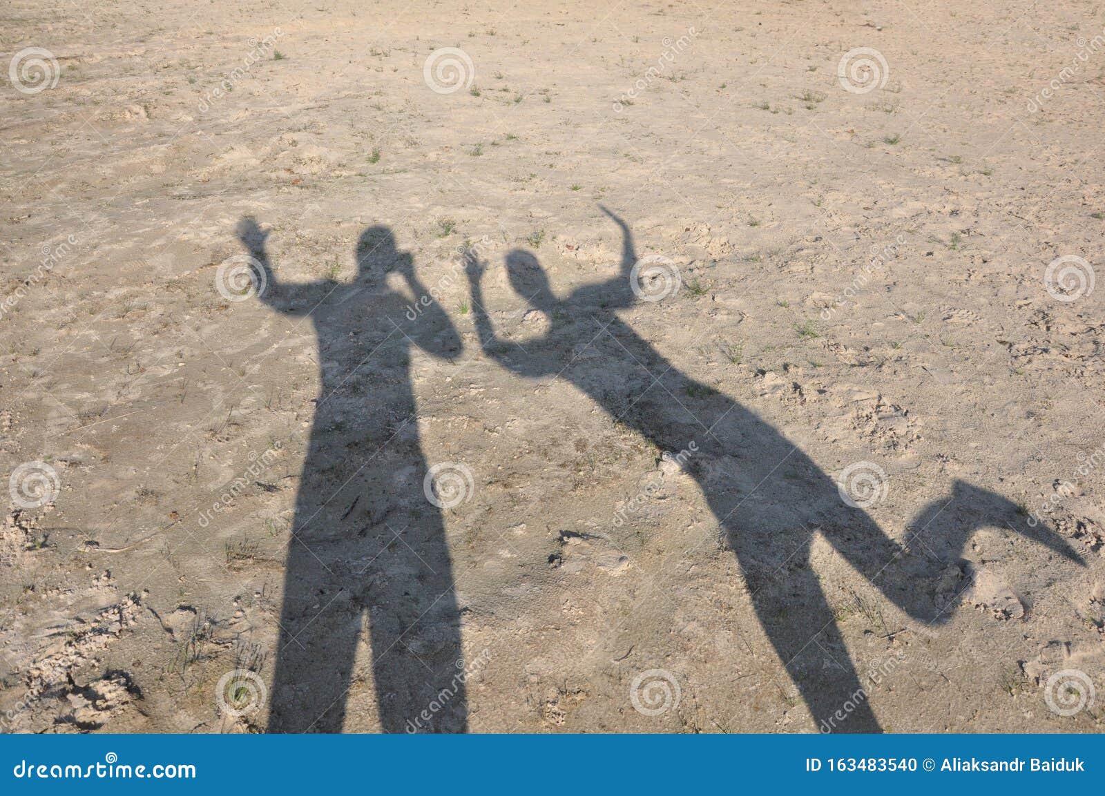 Blurred Shadows of People with Raised Hands on the Sand Stock Photo ...