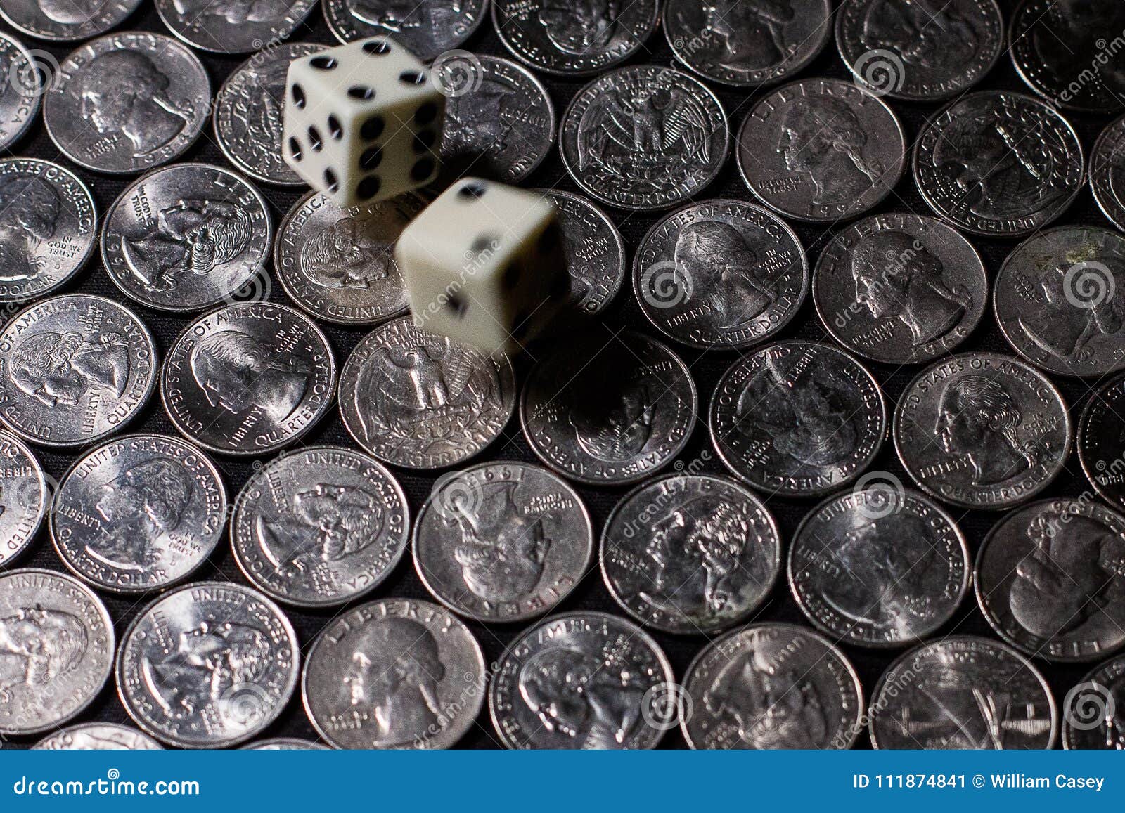 Blurry Dice Rolled Over Silver US Currency Quarters in a Uniform ...