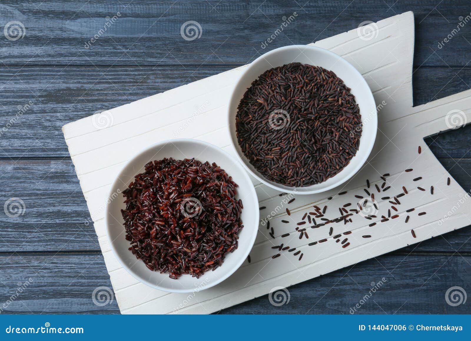 Board with Bowls of Boiled and Uncooked Brown Rice on Table Stock Photo ...