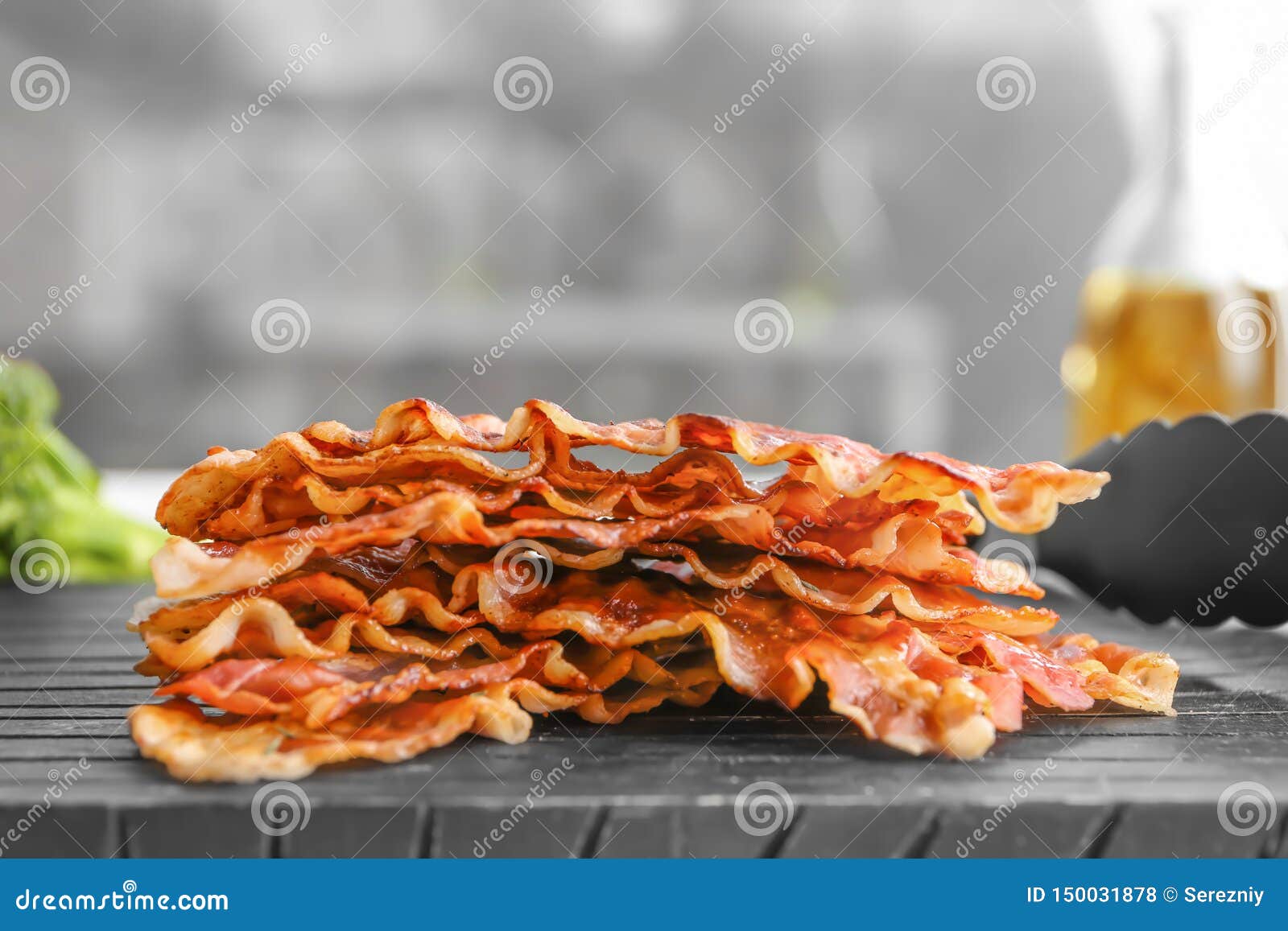 Board with Fried Bacon Rashers on Blurred Background Stock Photo ...