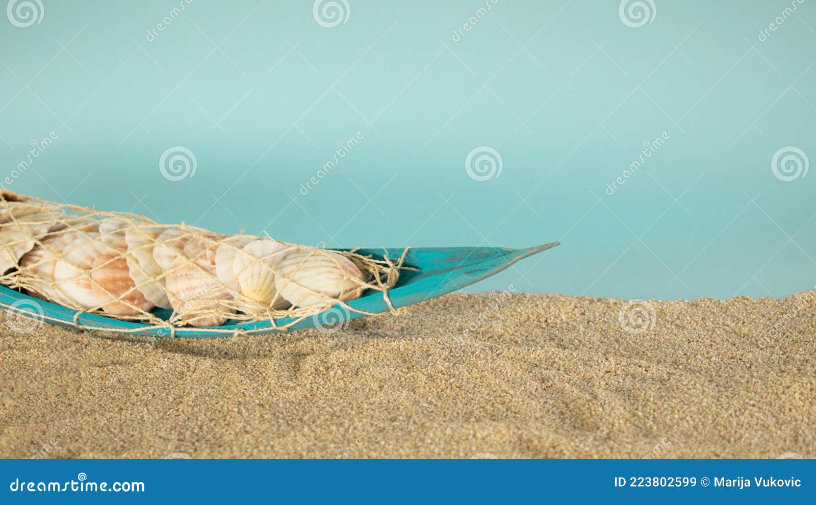 Boat with Shells on a Sandy Beach with Blue Background.travel Concept ...