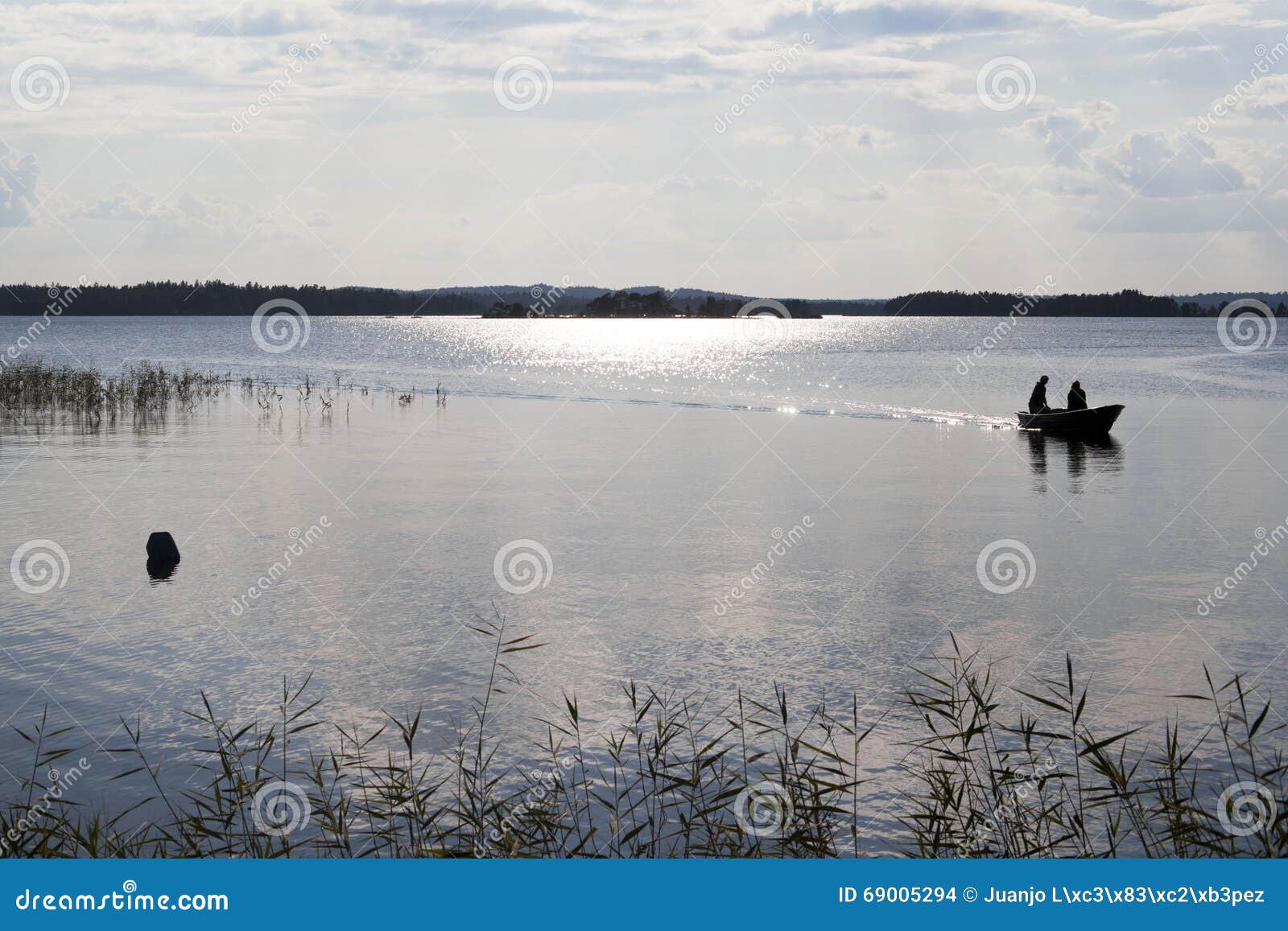 Boat with Two People Sailing on a Lake at Sunset Stock Photo - Image of ...