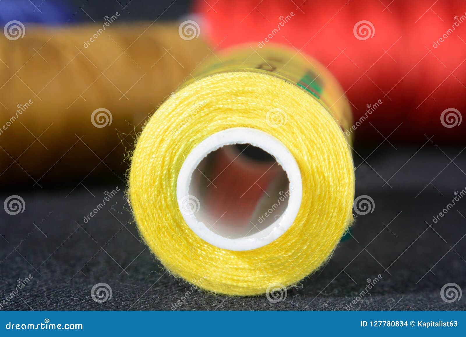 Bobbin of yellow threads stock photo. Image of shallow - 127780834