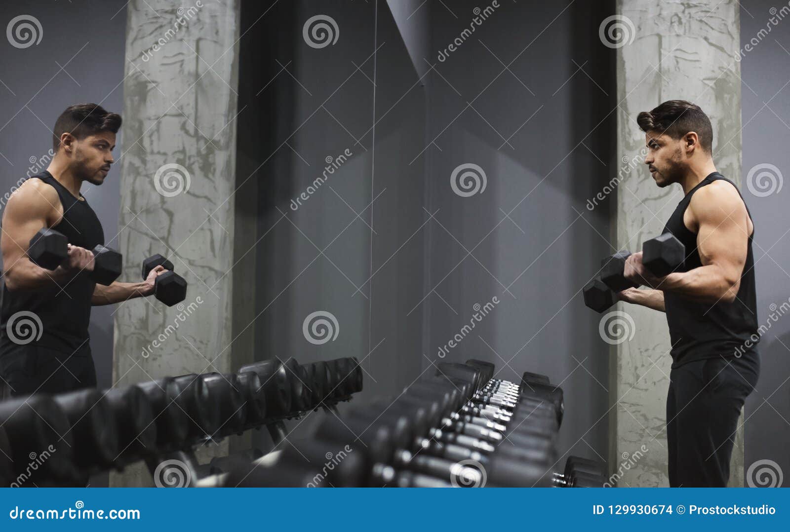 Good Looking Young Man Lifting Dumbbells in Front of Mirror Stock Photo ...