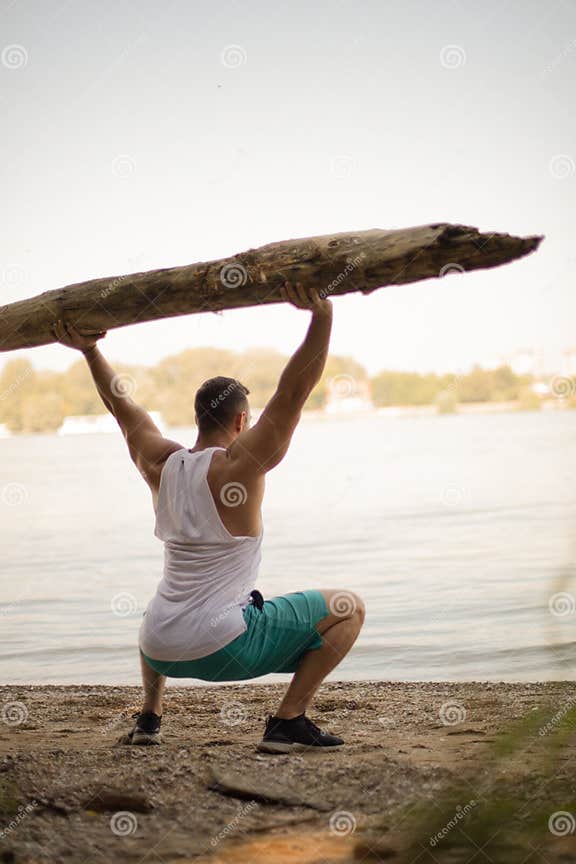 Bodybuilder on the Beach Picks Up a Tree. Stock Image - Image of ...