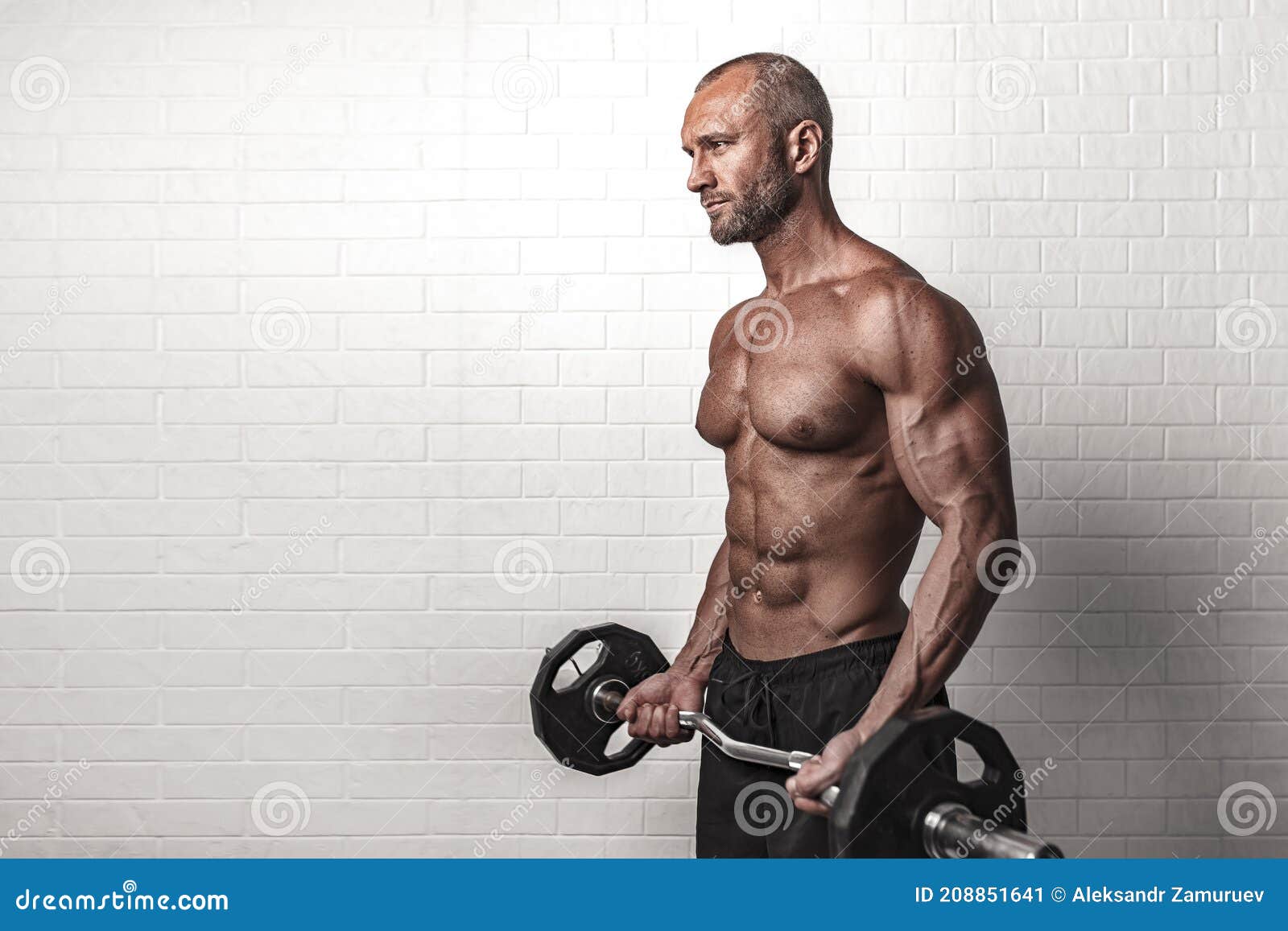 Bodybuilder Doing Exercises for Biceps with a Barbell Against Brick ...