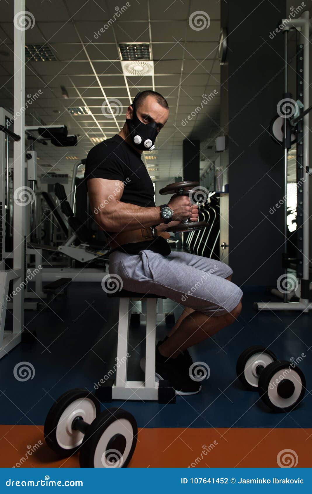 Bodybuilder Exercising Biceps with Dumbbells in Elevation Mask Stock ...