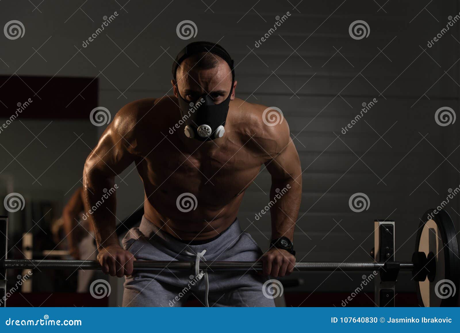 Bodybuilder Exercising Push-Ups on Barbell in Elevation Mask Stock ...