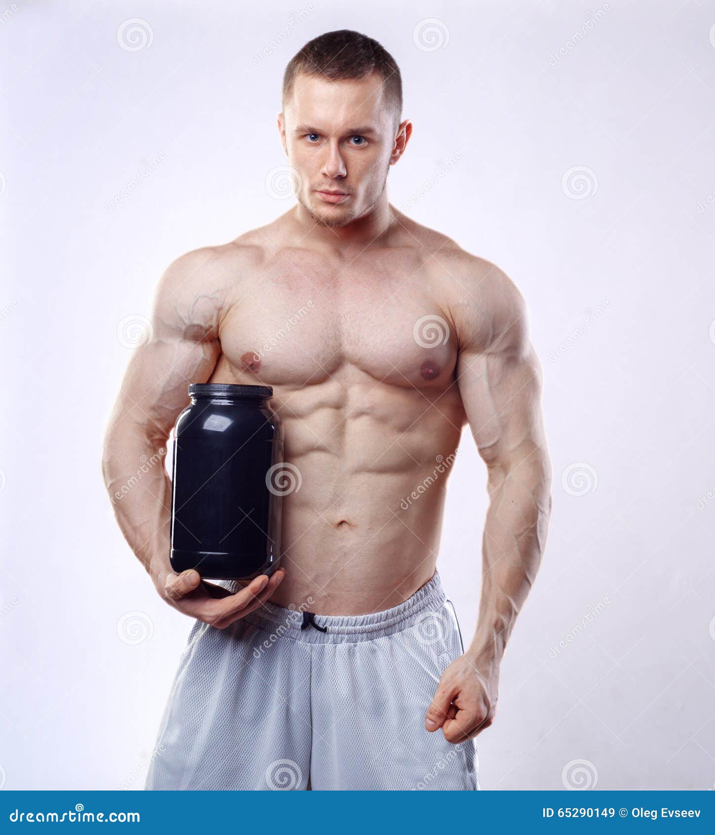 Bodybuilder Holding a Black Plastic Jar with Whey Protein on White ...