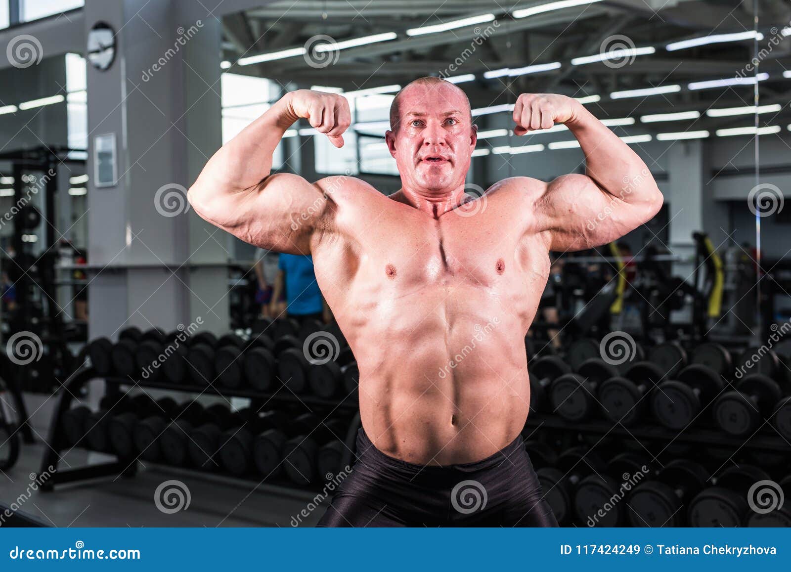 Bodybuilder Man with Perfect Biceps, Triceps and Chest in the Gym Stock ...