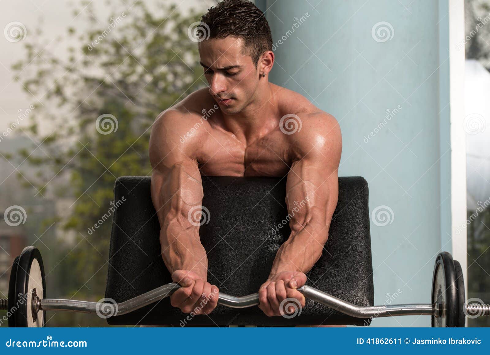 Bodybuilder Performing Biceps Curls with a Barbell Stock Image - Image ...