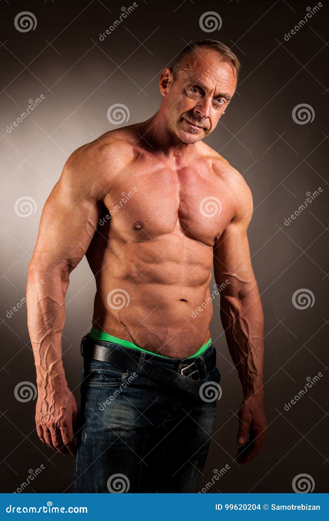 Bodybuilder Pose in Studio Over Dark Background Stock Photo - Image of ...