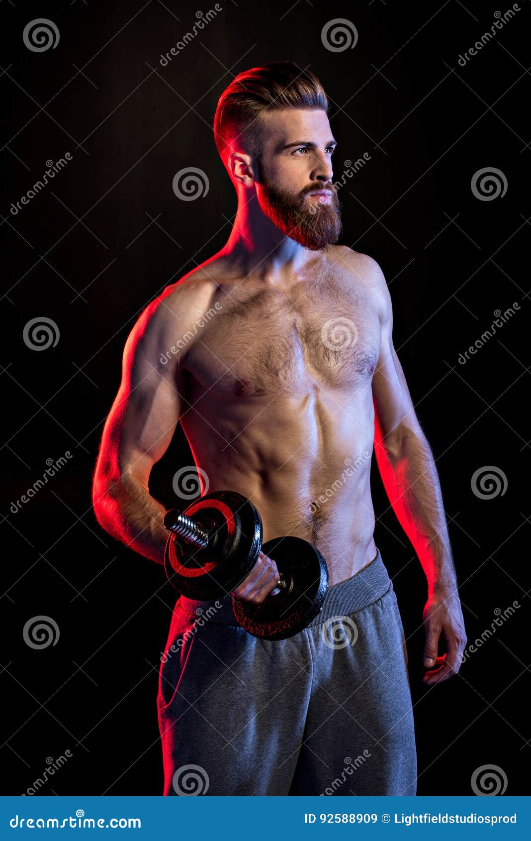 Bodybuilder Training with Dumbbell Isolated on Black with Dramatic ...